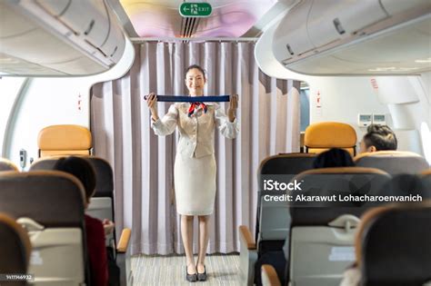 아시아 승무원이 객실 승무원 및 항공사 비즈니스 개념을 위해 비행기에서 이륙하기 전에 안전 벨트를 사용하여 안전 절차를 시연하고