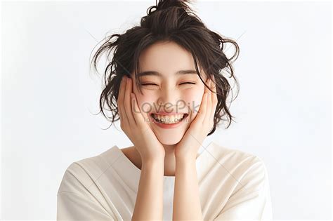 여성은 미소를 지으며 얼굴을 만집니다