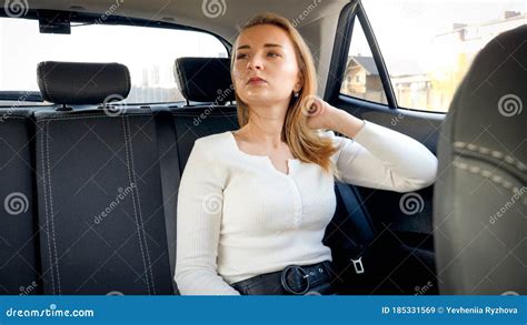 Portrait Of Blonde Woman Sitting On The Car Back Seat While Riing In