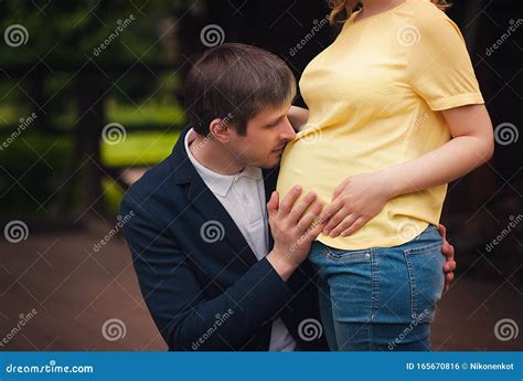 Image Of Beautiful Pregnant Woman And Her Handsome Husband Hugging The