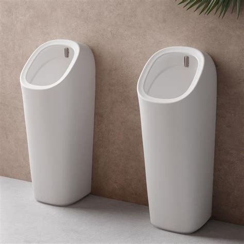 Two White Urinals Next To Each Other On A Wall