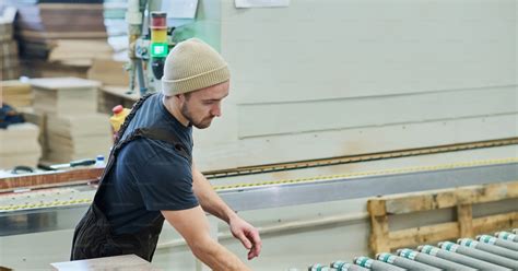 공장에서 가구를 생산하는 동안 기계에 나무 판을 씌우는 젊은 목수 사진 Unsplash의 목수 이미지