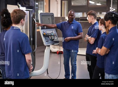 Engineer Showing Apprentices How To Use Cnc Tool Making Machine Stock