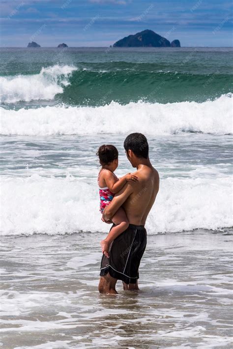 Premium Photo Rear View Of Shirtless Father Carrying Daughter In Sea