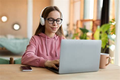 Pretty Teen Girl In Wireless Headset Using Laptop Interested Happy