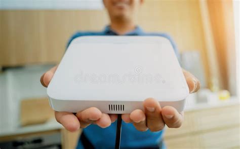 A Technician Installs A Main Unit Security System In A Modern Apartment