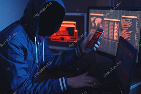 Un hacker anónimo sin rostro escribiendo el código intenta hackear el sistema y robar accesos en