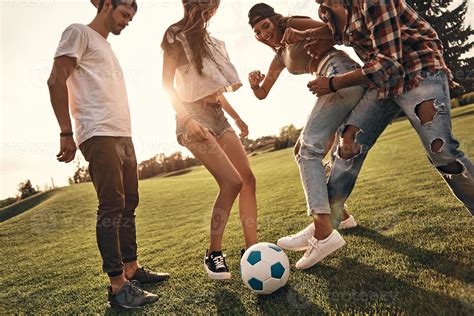 Group Of Young Smiling People In Casual Wear Fighting For The Ball