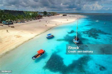 화창한 날에 모래 해변과 열대 바다 해안에 보트의 공중 보기 인도양 잔지바르 아프리카의 여름 휴가 보트 야자수 투명 한 푸른 물 하늘 풍경입니다 맨 위 보기 0명에 대한