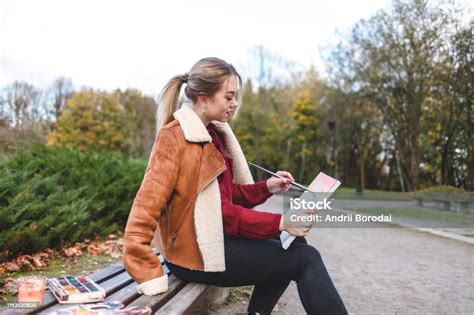 소녀 예술가가 벤치에 있는 공원의 캔버스에 그림을 그립니다 여자는 그녀의 손에 그것을 들고 그림을 그립니다 건강한 생활방식에 대한 스톡 사진 및 기타 이미지 Istock