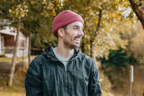 빨간 모자를 쓴 남자가 나무 앞에 서 있다 사진 Unsplash의 생활방식 이미지