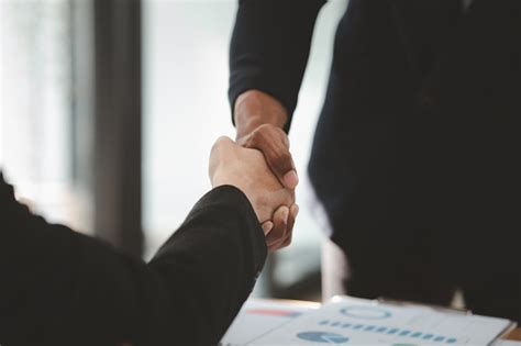 비즈니스 투자자 그룹이 손을 잡고 두 명의 사업가가 함께 사업에 동의하고 성공적인 협상 후 악수하고 있습니다 핸드 셰이킹은