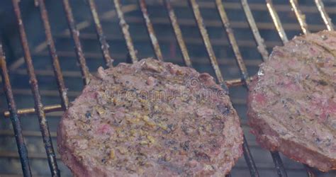 Close Up Of Hamburger Patties Cooking A Charcoal Grill With Flames