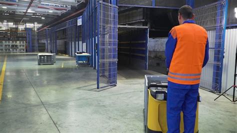 Premium Photo Worker On Loader Transports Boxes In Warehous Scene Worker Standing On Loader