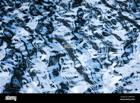 Blue water surface with abstract ripple pattern, top view. Natural background photo texture ...