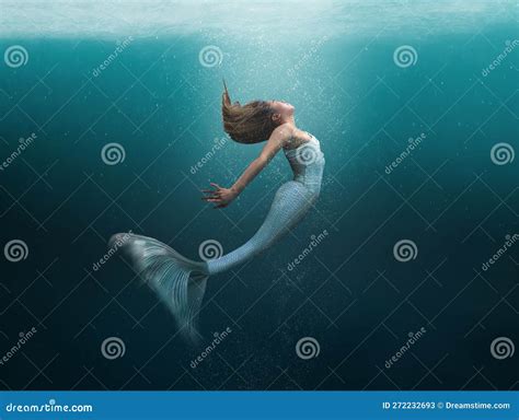 Mermaid In Graceful Swim Undersea With Sunlight Shinning Through The