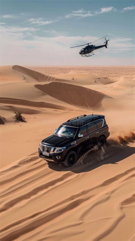 Black Suv Driving Through Desert Dunes With Helicopter Above Under