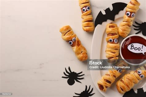 Flat Lay Composition With Tasty Sausage Mummies For Halloween Party On White Marble Table Space