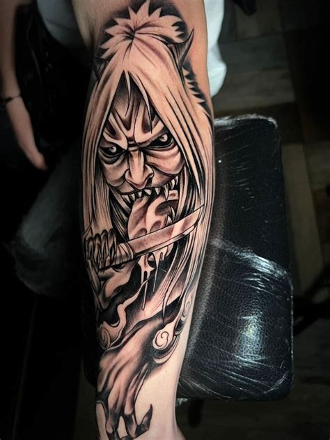 A Mans Leg With A Tattoo On It That Has An Image Of A Demon