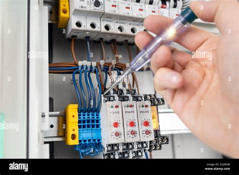 Electrician Testing Electrical Connections With Voltage Tester In Control Panel Stock Photo Alamy