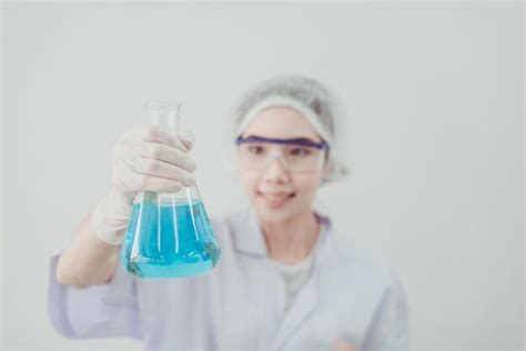 Científico sonriente sosteniendo un frasco cónico contra un fondo