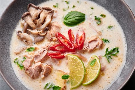 톰 카 가이 또는 태국 코코넛 치킨 수프 콘크리트 배경에 매트 회색 그릇에 수프 Tom Kha Gai는 코코넛 밀크 닭고기 갈란갈 레몬그라스 버섯 라임이 함유된 태국