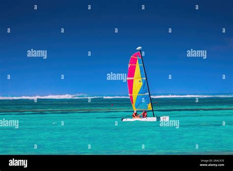 People On A Color Catamaran Sailboat Or Winsurf Sailing In Calm