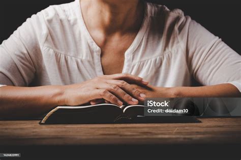 기독교 여성의 손을 거룩한 성경에 손을 대고 검은 배경을 가진 교회에서 하나님 께 감사하는 예배를하고 성인 여성 사람은 책 신앙 영성 및 종교에 대한 개념 40 49세에