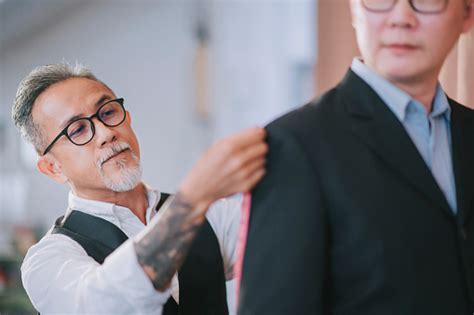 아시아 의 중국 노인 재단사 맞춤형 측정 테이프 측정 테이프 측정 그의 고객의 어깨를 측정 용 새로운 블레이저 만들기 에 대 한