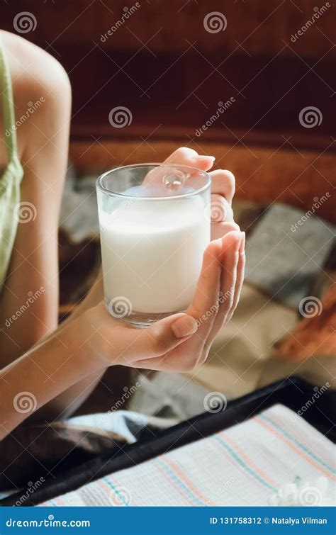 Pretty Young Brunette Enjoying A Glass Of Milk At Home And Smiling