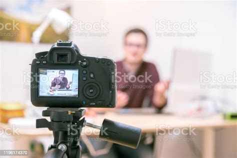 집에서 비디오 블로거 삼각대에 카메라는 자신의 작업 장소에 앉아 젊은 남자를 촬영하고있다 가정용 캠코더에 대한 스톡 사진 및 기타 이미지 Istock