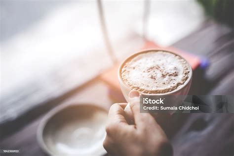 카푸치노 나 라 떼 커피 카페에서 나무 바탕에 거품 흰색의 여자 손 잡고 컵 이랑 초상화 화려한도 서 테이블에 쌓아 갈색에 대한 스톡 사진 및 기타 이미지 Istock