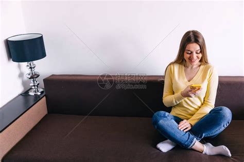 坐在沙发上看着智能手机屏幕的高清图片下载 正版图片504591787 摄图网