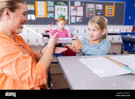 Practicing sign language, female teacher and student in school ...