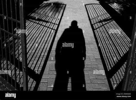 Foreboding Shadow Of Person Standing Legs Apart And Hands In Pockets