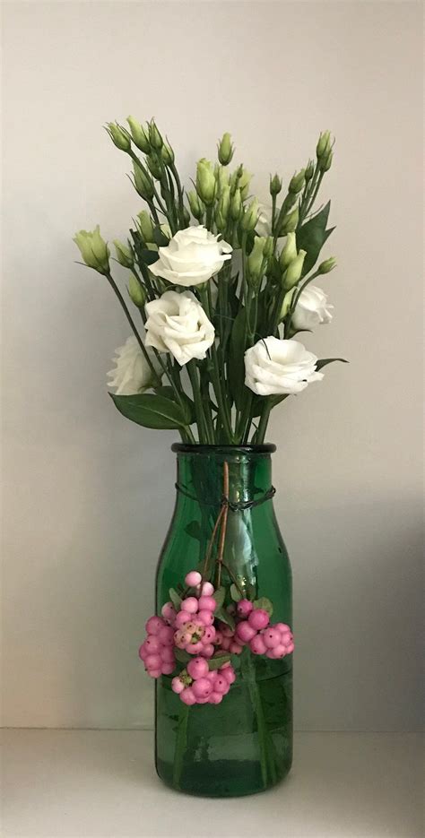 A Green Vase Filled With White And Pink Flowers