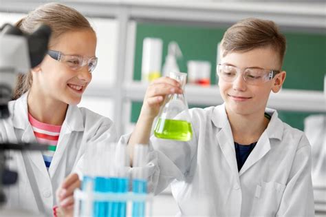 Niños con tubos de ensayo estudiando química en la escuela Foto Premium