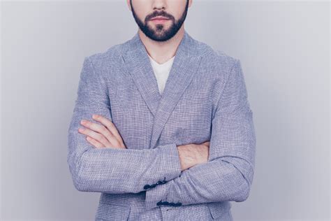 회색 자 켓에 젊은 잘생긴 Brunet 수염된 사업가 변호사의 자른 초상화를 닫습니다 그 순수한 빛 바탕에 서 있다 그래서 성숙