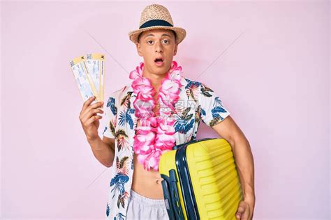 身穿夏季风气的年青西班牙男孩拿着小行李箱和登机罚单当着休克的脸高清图片下载 正版图片503710605 摄图网