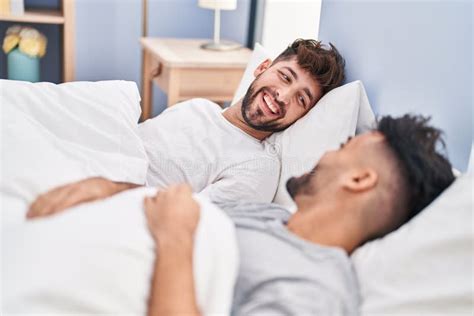 Pareja Joven Sonriente Confiada Sobre La Cama En El Dormitorio Foto De Archivo Imagen De Barba