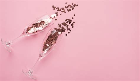 파티 개념 상단 오버 헤드 보기 복사 공간과 파텔 핑크 배경에 고립 된 색종이로 가득 찬 두 개의 샴페인 피리 사진을 닫습니다