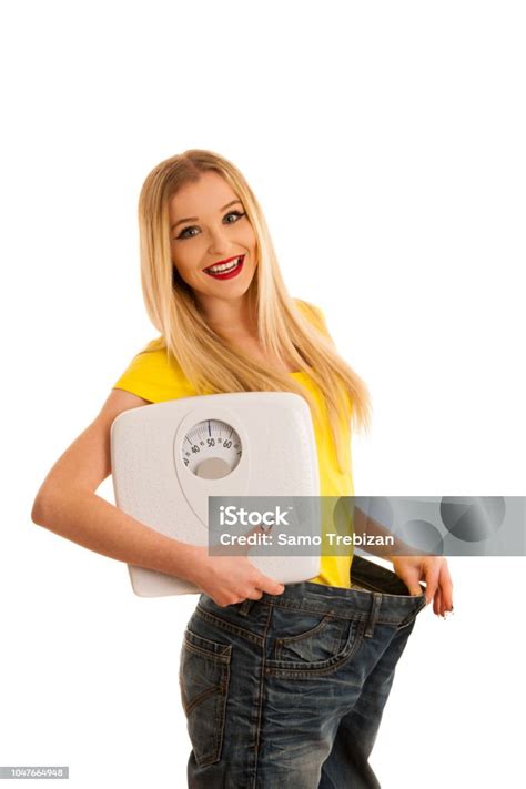 그녀는 체중 흰색 배경 위에 절연 규모와 너무 큰 바지 들고 행복 Womman 가냘픈에 대한 스톡 사진 및 기타 이미지