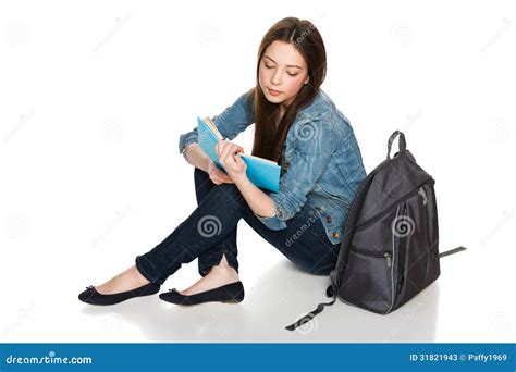 Estudiante Que Se Sienta En Piso Con La Mochila Que Lee Un Libro Imagen
