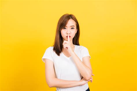 여자 대 미소 서 서 착용 T 셔츠 만들기 손가락 에 입술 침묵 조용한 제스처 20 29세에 대한 스톡 사진 및 기타 이미지