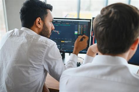 Premium Photo Two Successful Trader Sitting In Office And Looking At