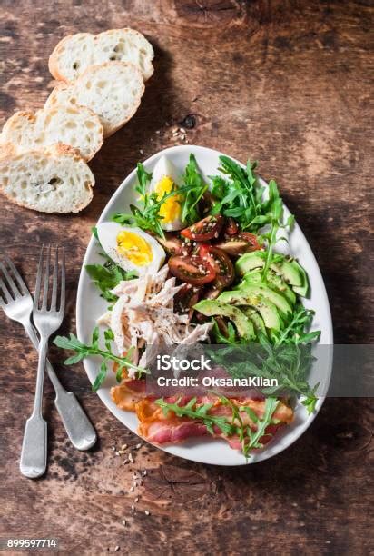 부활절 브런치삶은 닭고기 아보카도 계란 Arugula Kumato 토마토 나무 갈색 배경 평면도에 베이컨 샐러드 부활제에 대한