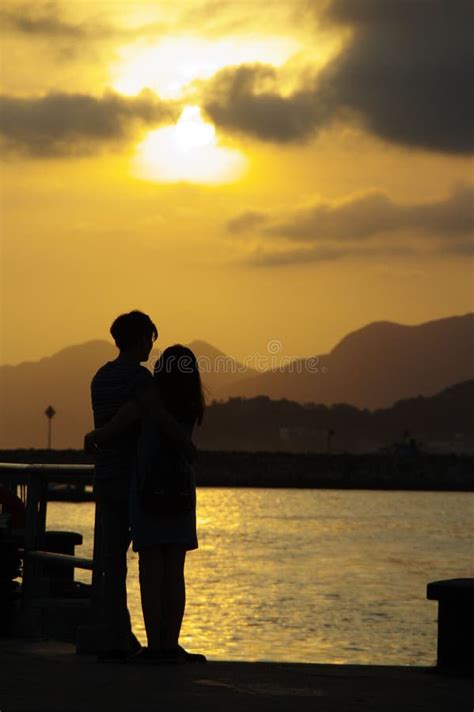 Shot Of The Silhouette Of A Hugging Couple By A Lake The Mountains On