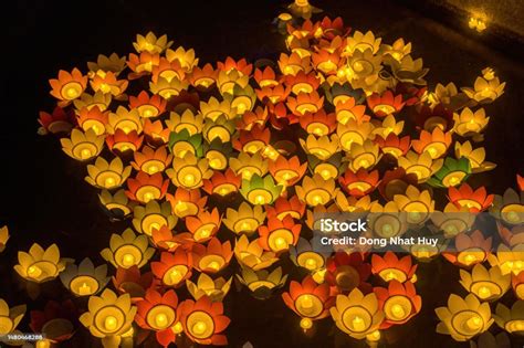 종이와 촛불로 만든 밤에 부처님의 생일을 축하하기 위해 Vesak 낮 날에 밤에 강에 떠 다니는 색색의 등불과 화환 돌아가신