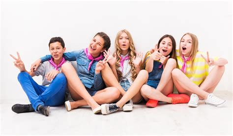 Premium Photo Cute Smiling Tenagers Sitting On The Floor With Legs