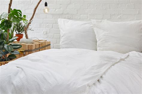 도시 로프트 침실 흰색 침대 린 넨 및 식물을 가진 창조적인 Nighstand 흰색에 대한 스톡 사진 및 기타 이미지 흰색